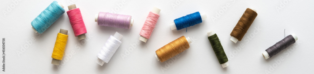 Panoramic view on sewing composition with threads on white background ...