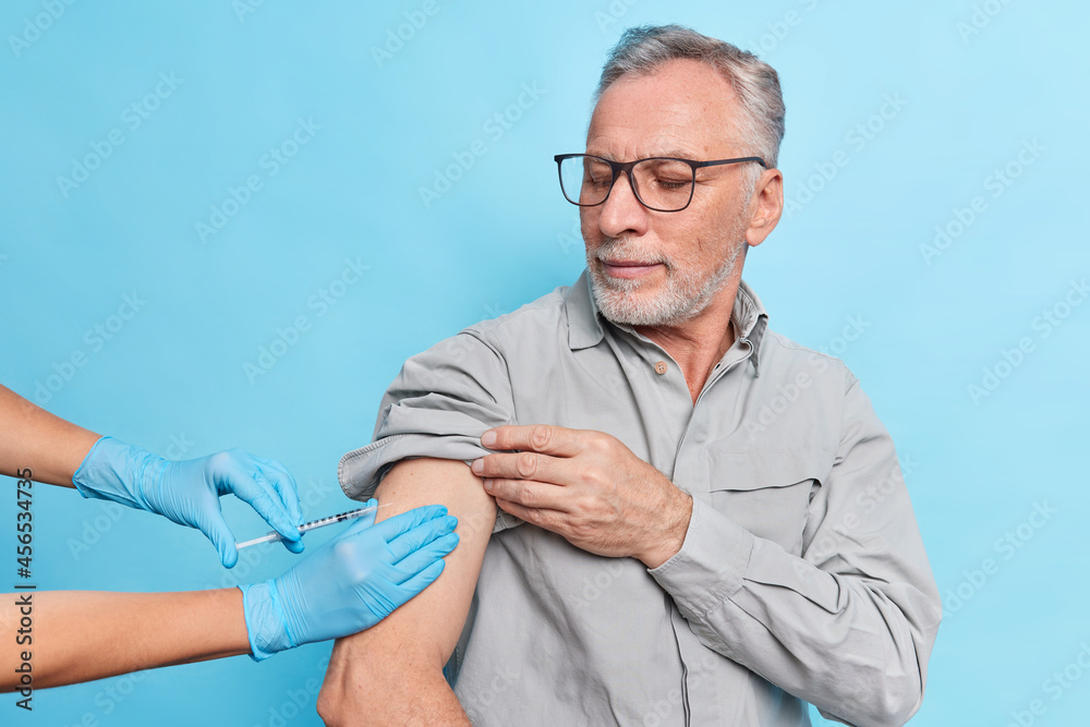 Unrecognizable doctor makes injection to senior patient. Elderly man ...