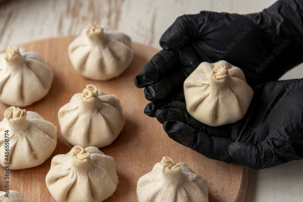 making khinkali for his family close-up. Unrecognizable cook preparing ...