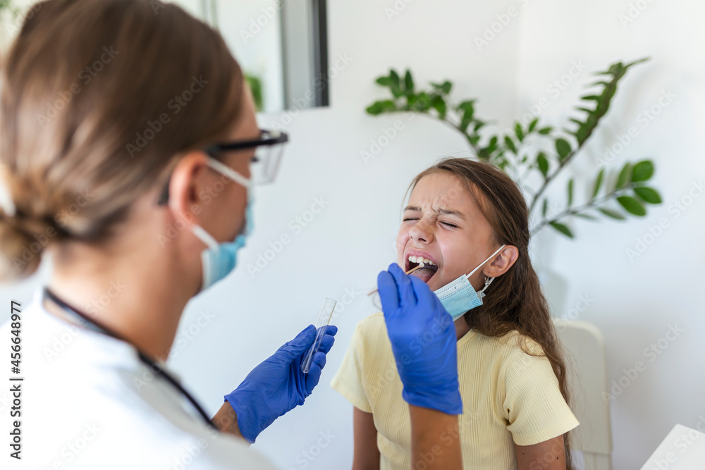 Nurse performing a mouth swab test on a little child. Girl going ...