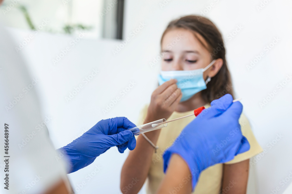 Nurse performing a mouth swab test on a little child. Girl going ...