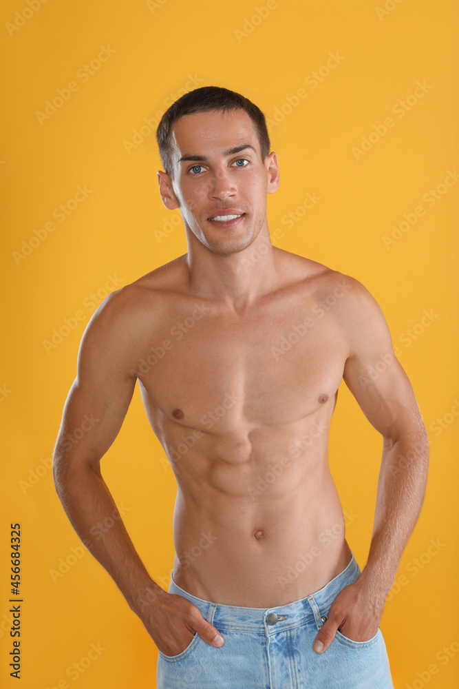 Handsome shirtless man with slim body on yellow background Stock Photo ...