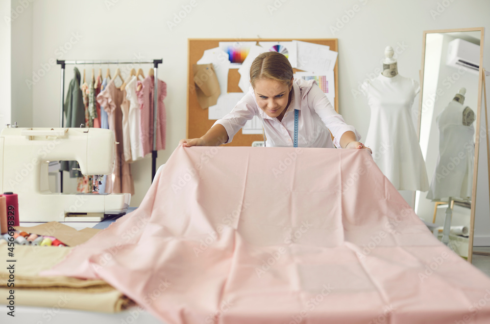 Dressmaker making clothes. Seamstress working in her studio. Tailor ...