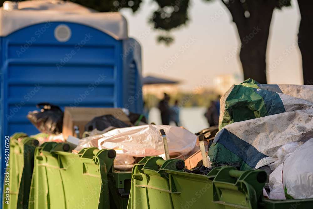 Overflowing waste bins and portable toilet after public event ...