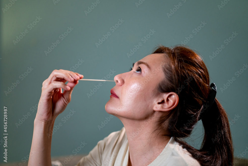 Asian woman using rapid antigen test kit for self test COVID-19 ...