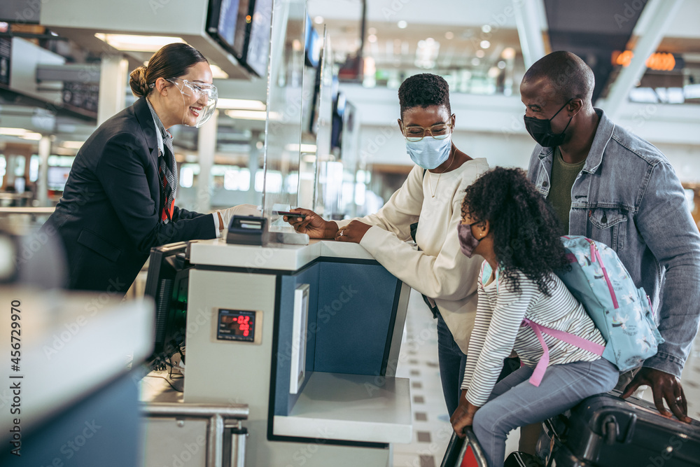 Traveler family at airport check-in counter Stock Photo | Adobe Stock