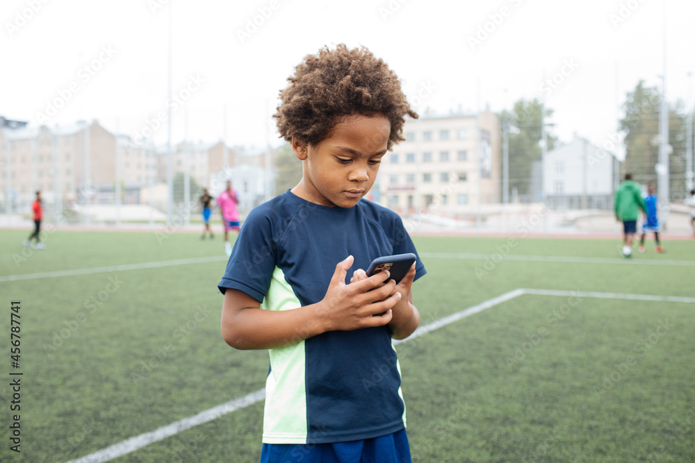 Smiling and excited black boy showing smartphone empty screen. Looking ...
