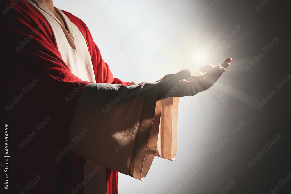 Jesus Christ on grey background, closeup. Miraculous light in hands ...