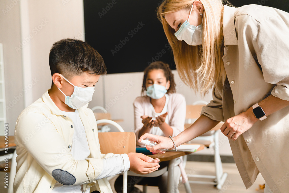 Sanitary measures against Covid19 coronavirus spread at school. Teacher ...