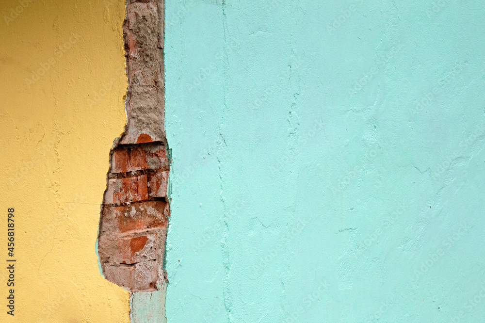 backdrop of an old and deteriorated house wall in yellow and blue ...