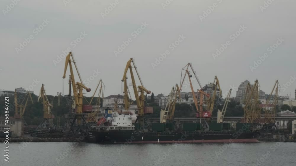 Bulk carrier ship under load of clinker cargo loading by shore cranes ...