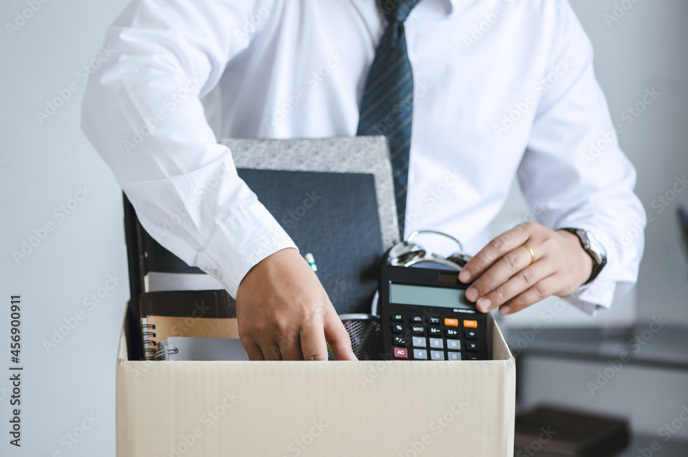 personnel packing personal belongings and files into a brown cardboard ...