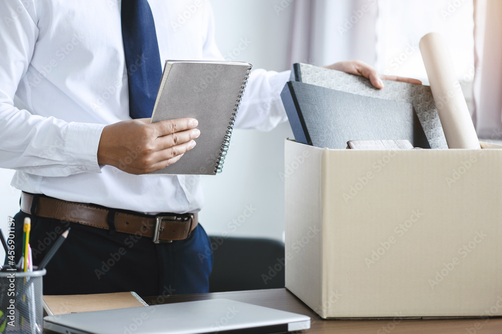 personnel packing personal belongings and files into a brown cardboard ...