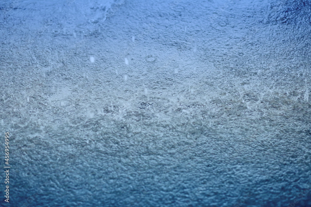 Blue color tone of close up rain water drop falling to the floor in ...