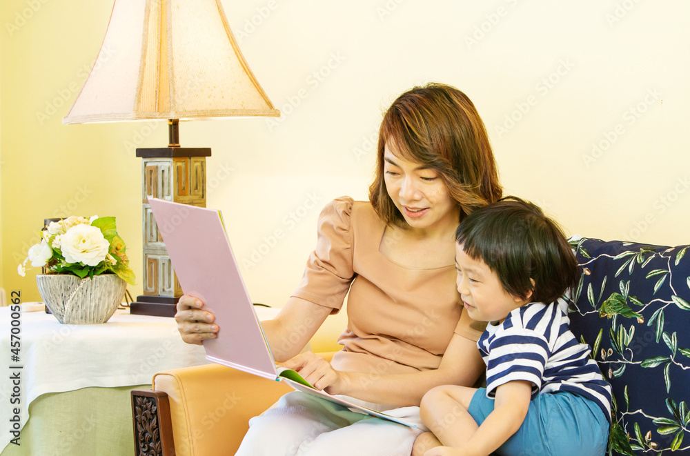 Young boy reading book and studies at home with his mom. Home school ...
