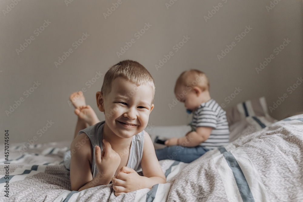 The two brothers' children are on the bed. The older four-year-old is ...