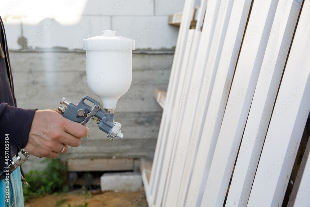 Close-up of a spray gun in a man hand. The process of painting the ...