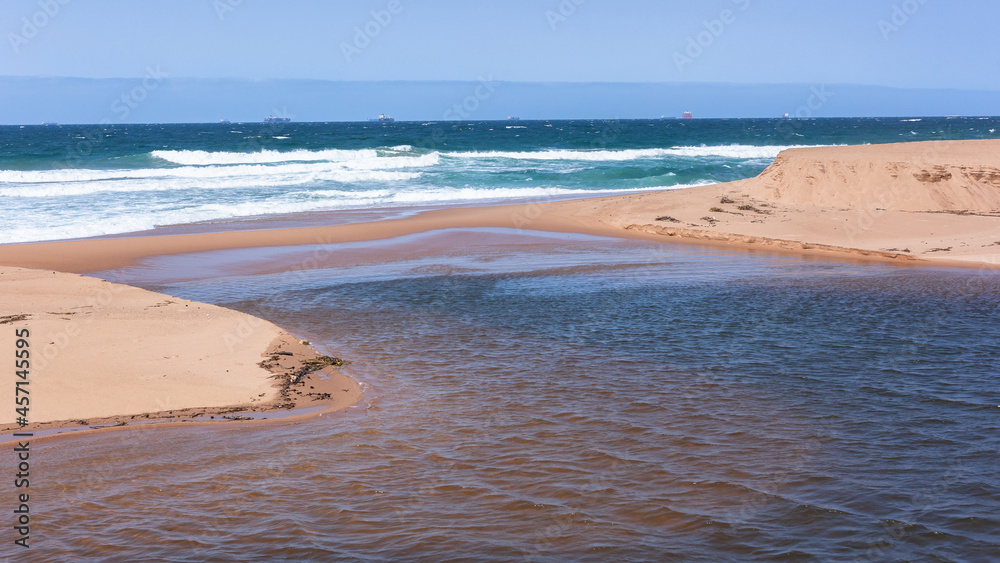 Beach sandbanks with open river water flowing from lagoon towards the ...