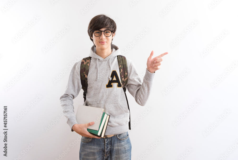 Handsome teen boy students carrying a backpack and books pointing ...