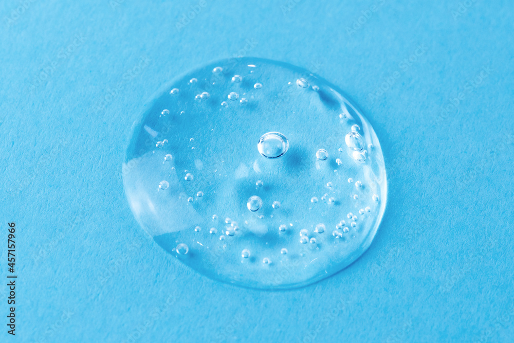 Gel drop with bubbles on blue background. Antibacterial gel or facial ...
