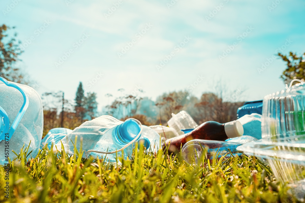Garbage close-up. A lot of plastic waste lies in the park on the grass ...