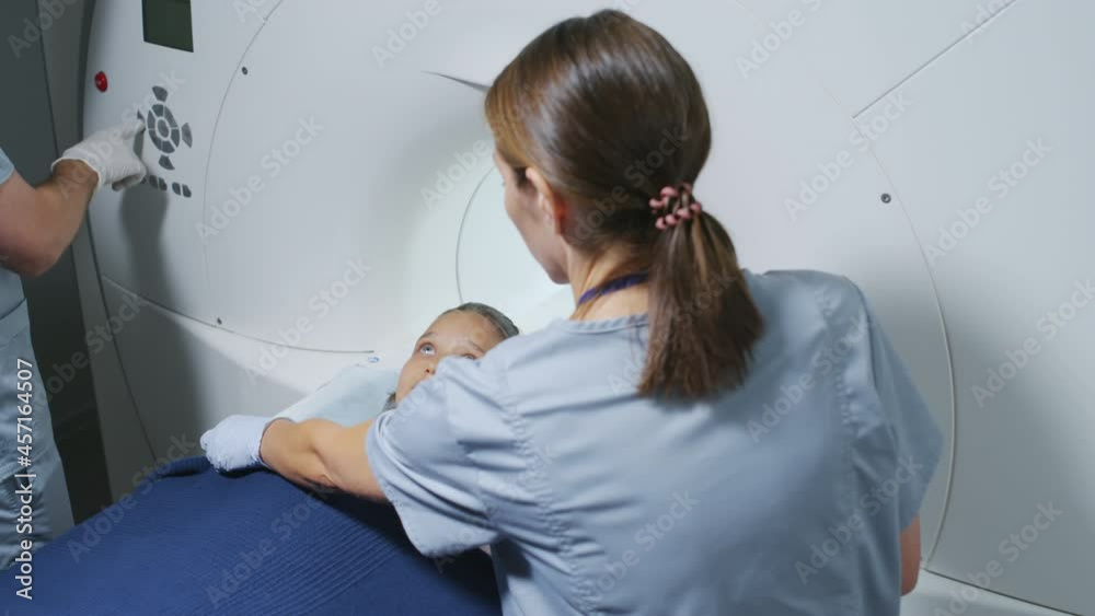 Slowmo shot of little girl lying on couch having MRI examination in ...