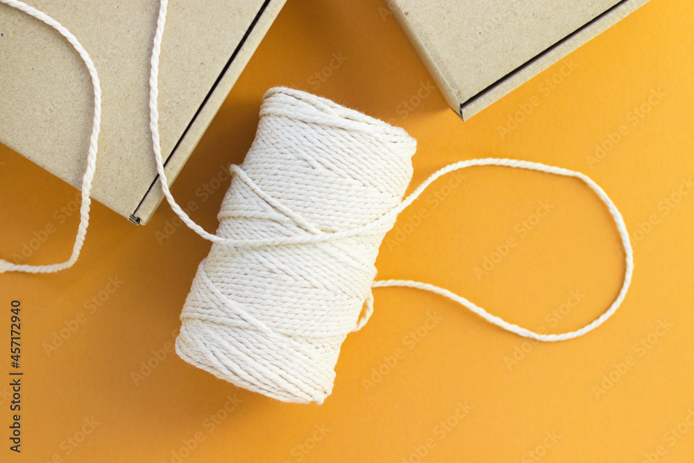 Bobbin of cotton rope and cardboard boxes. Eco-friendly packing, parcel ...