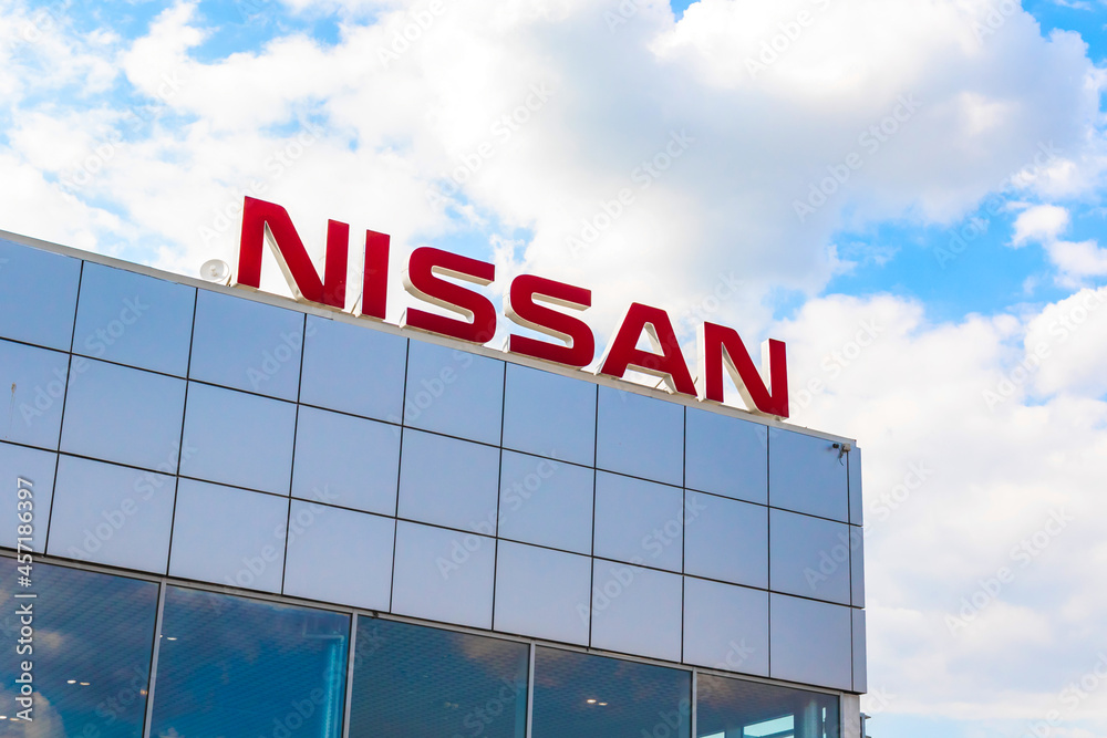 Nissan brand logo on bright blue sky background, emblem, symbol close ...