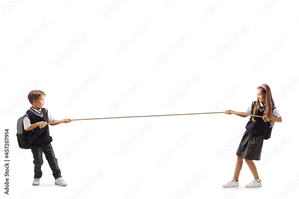 Full length profile shot of a schoolgirk and schoolboy pulling a rope ...