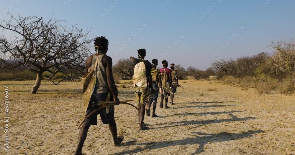Back view of a group of Hadza hunter-gatherer tribesmen out hunding ...