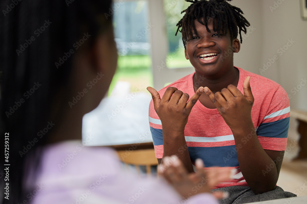 Teenage Boy And Girl Having Conversation Using Sign Language At Home ...