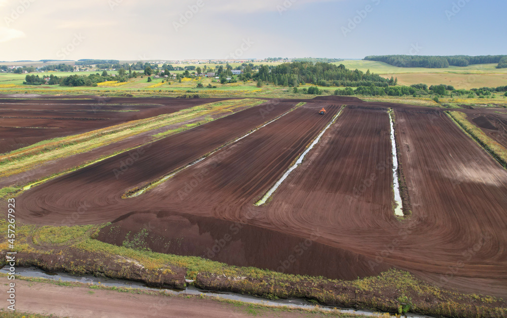 Peat extraction site. Harvester at collecting peat on peatlands. Mining ...