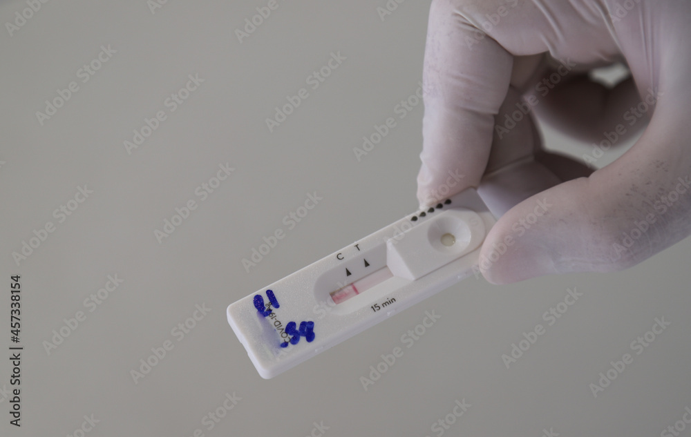 Closeup of hand with glove holding rapid antigen test kit, ATK for ...