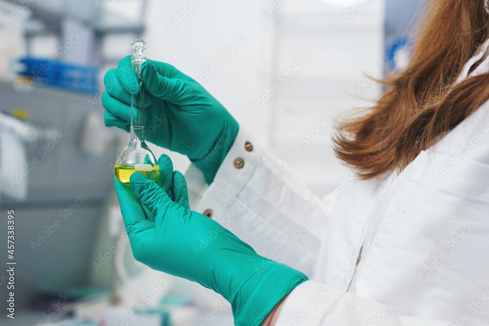 Researcher in chemical laboratory holds a flask in his hands. Close-up ...