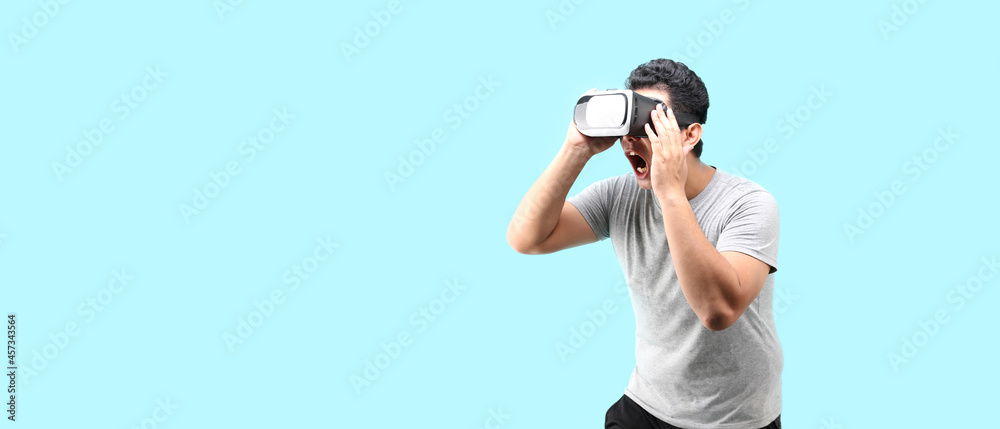 Asian man playing VR video game with virtual reality goggles and Shock ...