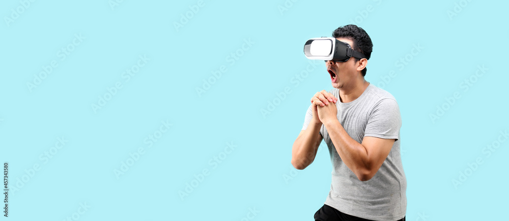 Asian man playing VR video game with virtual reality goggles and Shock ...