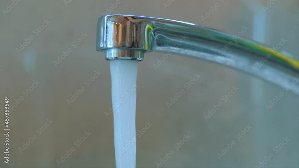 Tap water flows from the tap. Drinking water at the tap. Faucet in the ...