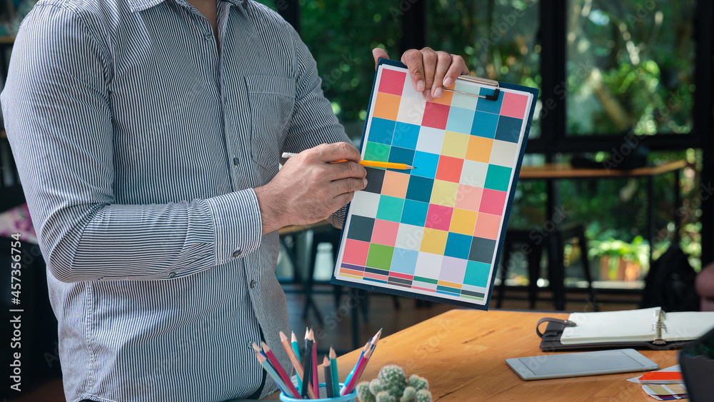 Young man holding and point to a color chart for home design. Graphic ...