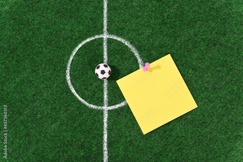 Soccer ball in the center of the soccer field and stationery push pins ...