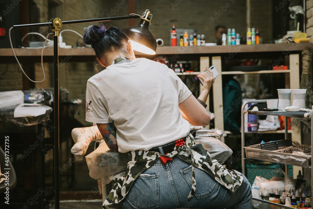 Portrait of a woman tattoo master showing a process of creation tattoo ...