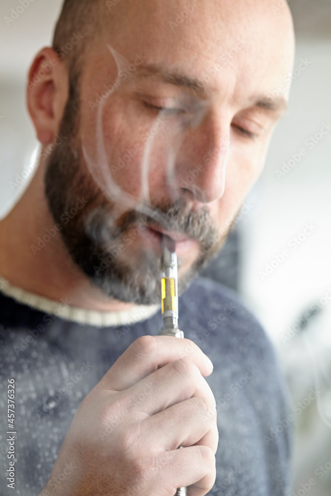 man vaping cannabis distillate with vape pen Stock Photo | Adobe Stock