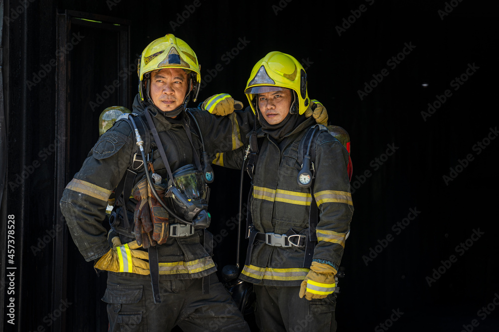 Fireman wearing firefighter turnouts holding helmet ready for emergency ...