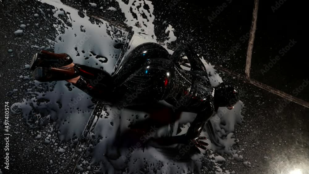 lady is wearing black latex suit is lying in white puddle on black ...