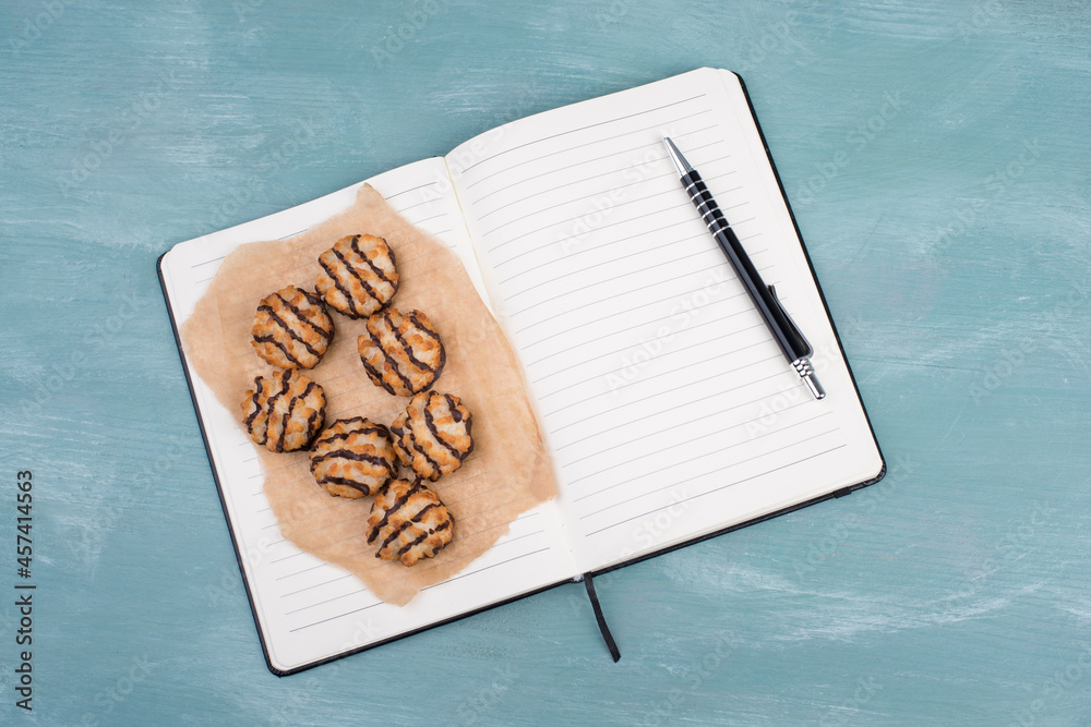 Coconut macaroons on a textured blue background, empty booklet with a ...