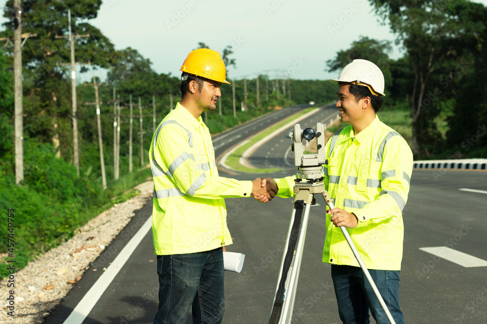 Road construction workers use orthogonal surveyors to measure angles in ...