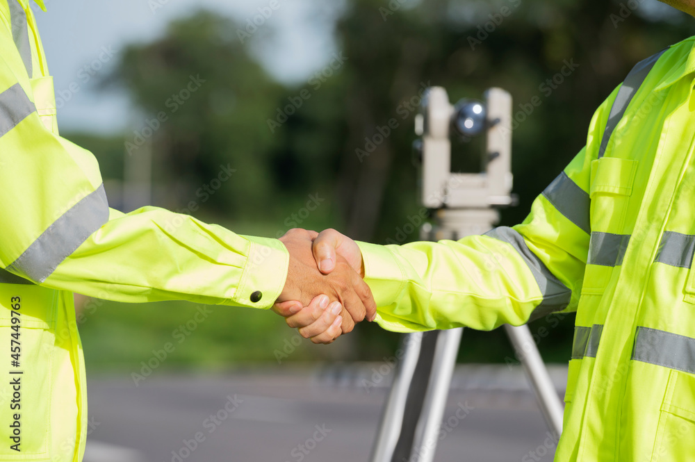 Road construction workers use orthogonal surveyors to measure angles in ...