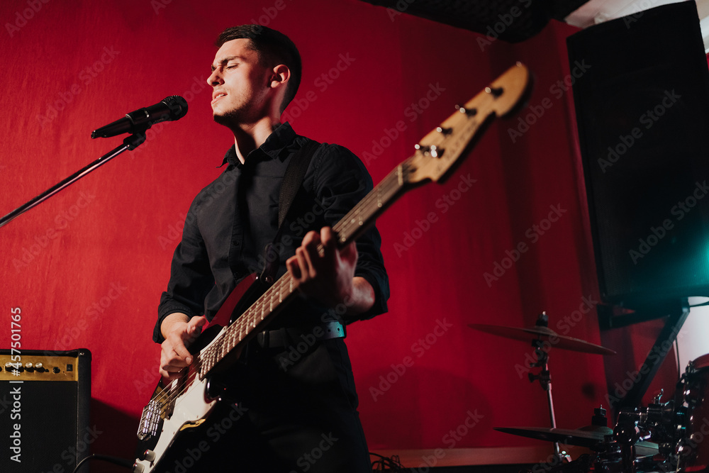 Talented handsome young guitarist man singing a song in studio ...