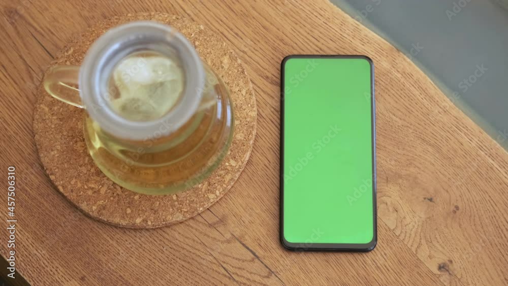 Smartphone place on table wood with green screen, Close-up the cell ...