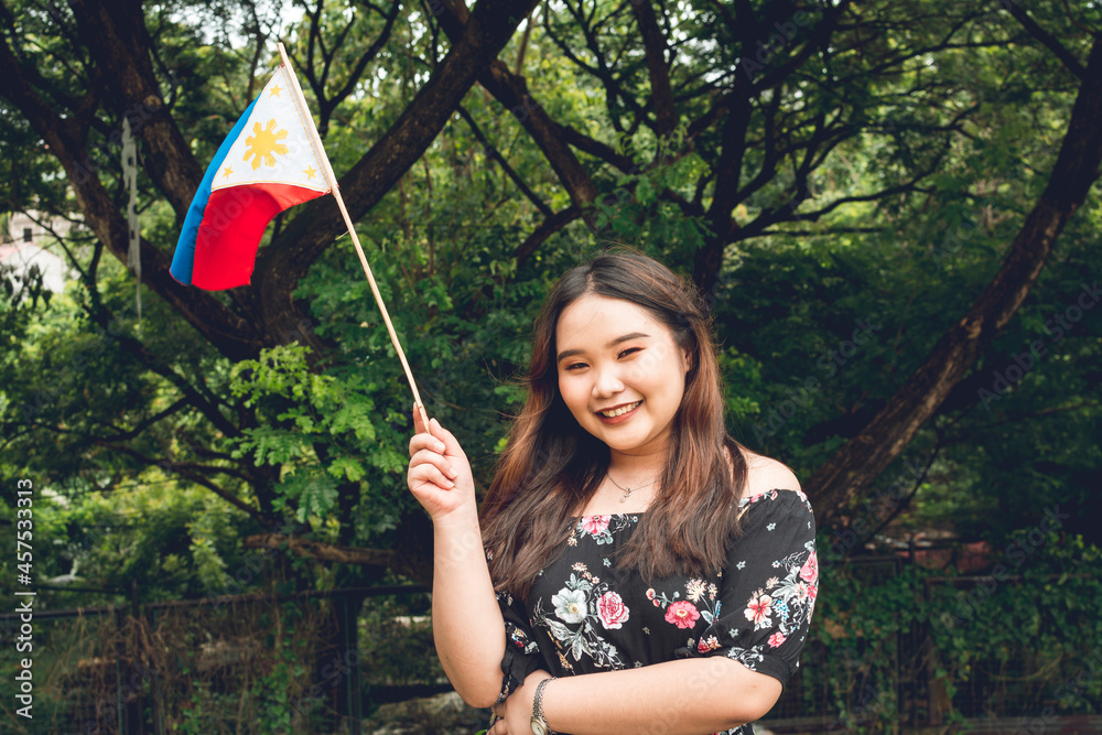 A cute and chubby Chinese Filipino woman proudly waving the Philippine ...