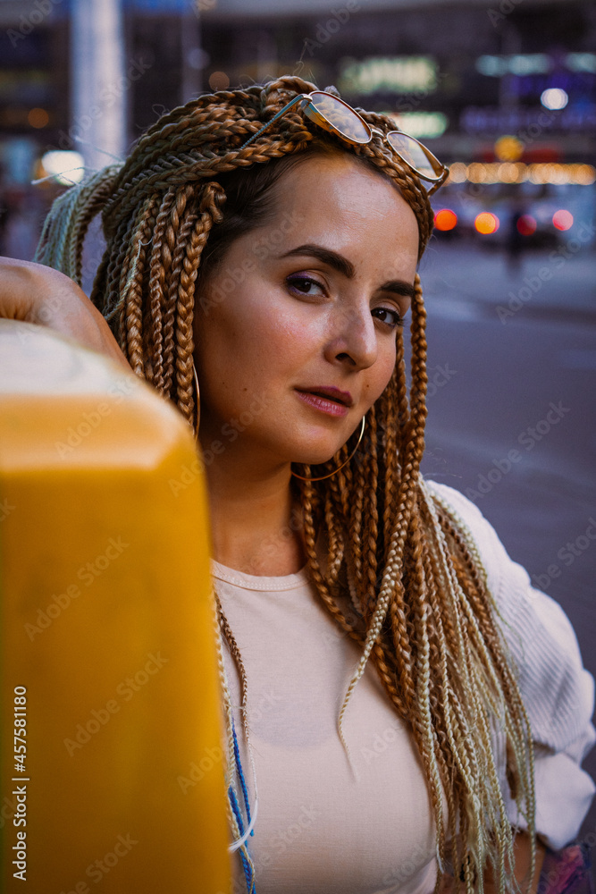 young woman with afro zizi braids and bright makeup in a big city ...